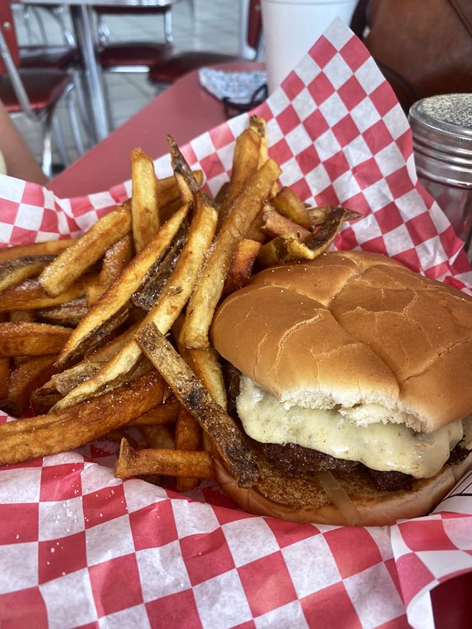 The classic cheeseburger and fries combo—proof that sometimes the simplest pleasures deliver the most profound satisfaction.