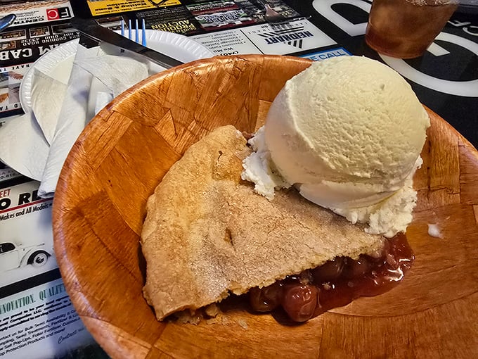 Cherry pie à la mode served on a wooden plate – rustic presentation for a dessert that tastes like summer memories.
