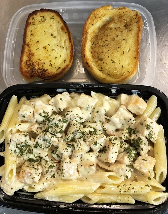 Garlic bread standing guard over creamy chicken alfredo pasta—proof that soul food cafes contain multitudes and defy simple categorization.