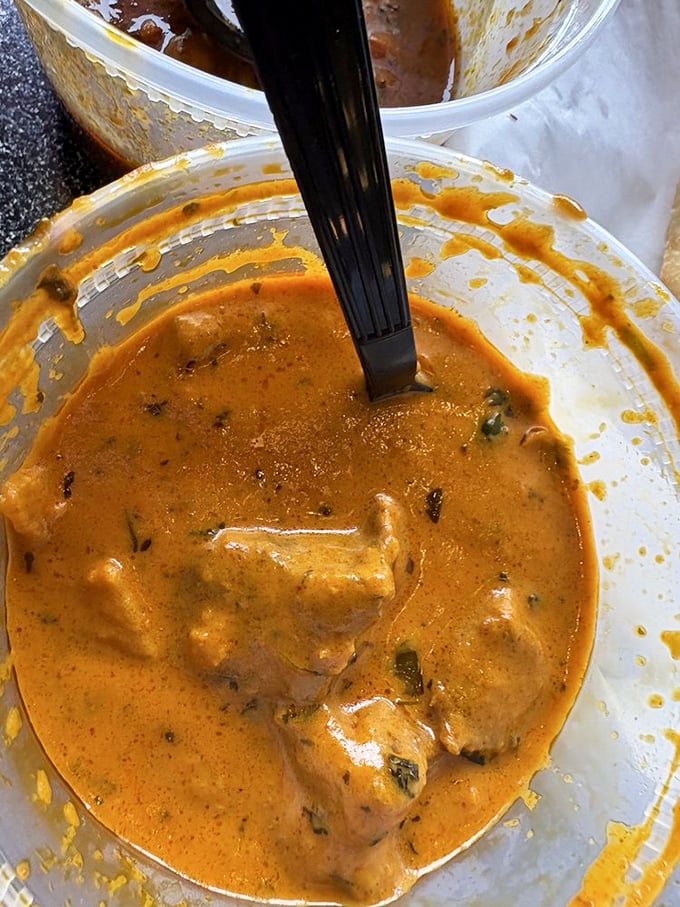 A plastic spoon has never looked so outmatched—this chicken curry demands respect and possibly a moment of silent appreciation.
