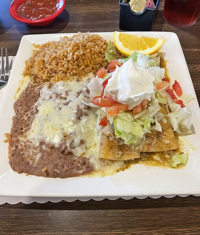 That enchilada plate comes loaded with rice, beans, and enough melted cheese to make your cardiologist reach for the tissues.