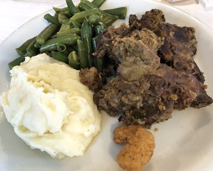 Comfort on a plate: meatloaf with mashed potatoes and green beans—the holy trinity of Midwestern cuisine that never goes out of style.