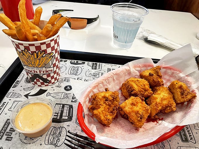Chicken nuggets and fries presented on classic red-checkered paper—proof that childhood favorites can still deliver grown-up satisfaction when done right.