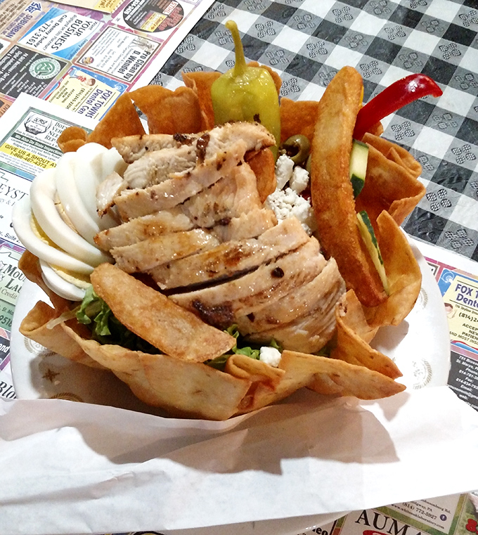 A chicken salad that doesn't mess around—crisp greens, perfectly grilled meat, and a tortilla bowl that says "yes, you can eat your dishes."