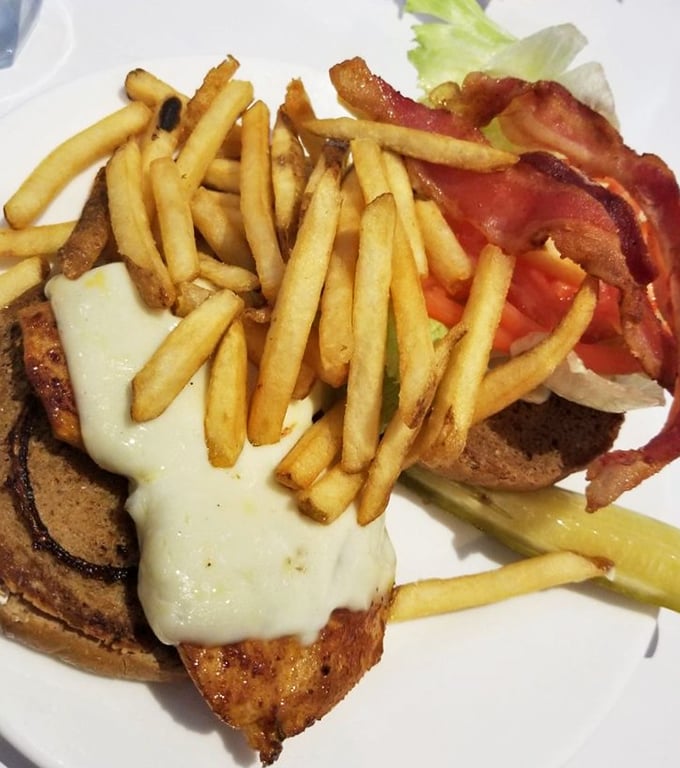This isn't just a chicken sandwich; it's architecture. The melted cheese cascading over the edge like a dairy waterfall deserves its own Frank Lloyd Wright award.
