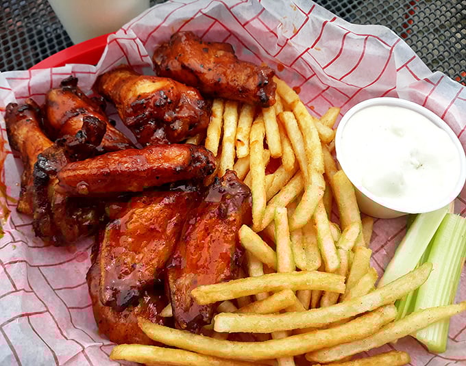 Chicken wings glazed to mahogany perfection alongside golden fries—proof that sometimes the simplest pleasures are the most profound.