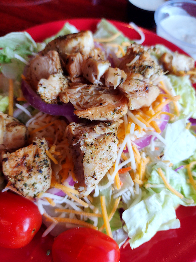Fresh, colorful salad topped with grilled chicken proves that even barbecue joints understand the importance of balanced dining.