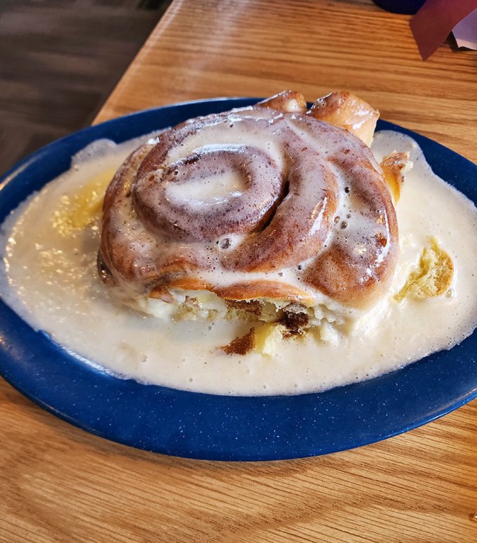 The legendary cinnamon roll, swimming in a pool of sweet cream sauce – dessert masquerading as breakfast and nobody's complaining.