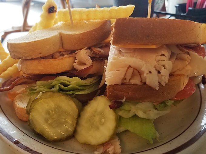 Not just a sandwich, but a skyscraper of layers—crisp lettuce, juicy tomato, and tender meat between the supportive scaffolding of toasted bread.