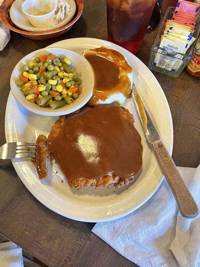 Country fried steak smothered in gravy with mashed potatoes—a plate that says "nap time is imminent" but worth every drowsy moment.
