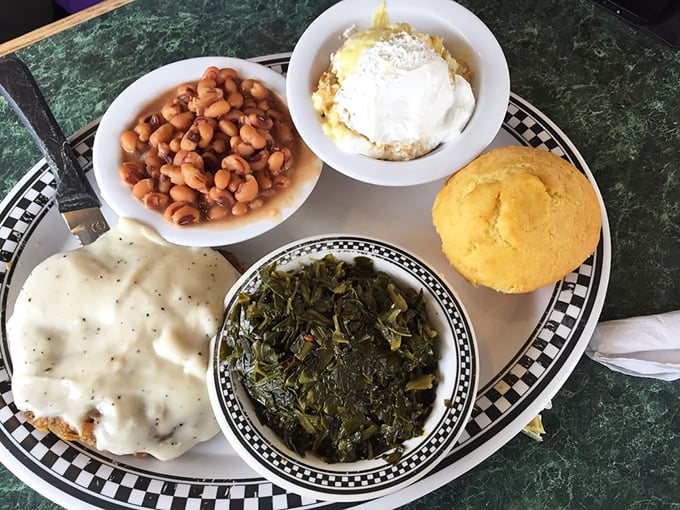 Southern comfort on a plate – where biscuits swim in pepper gravy, collard greens whisper family secrets, and cornbread stands proudly alongside.