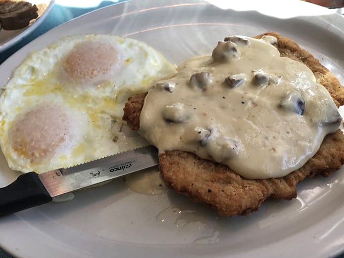 Country fried pork with mushroom gravy and eggs—because some mornings require more fortification than a cup of kale smoothie could ever provide.