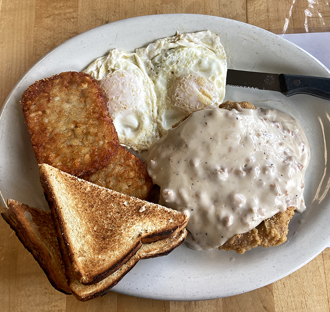 Country fried steak smothered in peppery gravy alongside sunny-side-up eggs and golden toast—the breakfast trifecta that fuels Connecticut's finest.