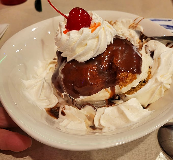 A dessert that doesn't whisper sweet nothings—it shouts them. That hot fudge is doing a slow dance with whipped cream and a cherry on top.