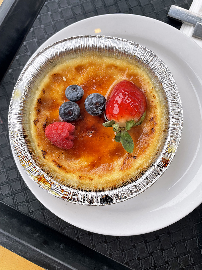 Crème brûlée with fresh berries—where the gentle "crack" of caramelized sugar gives way to silky custard beneath, creating that perfect textural tango in every spoonful.