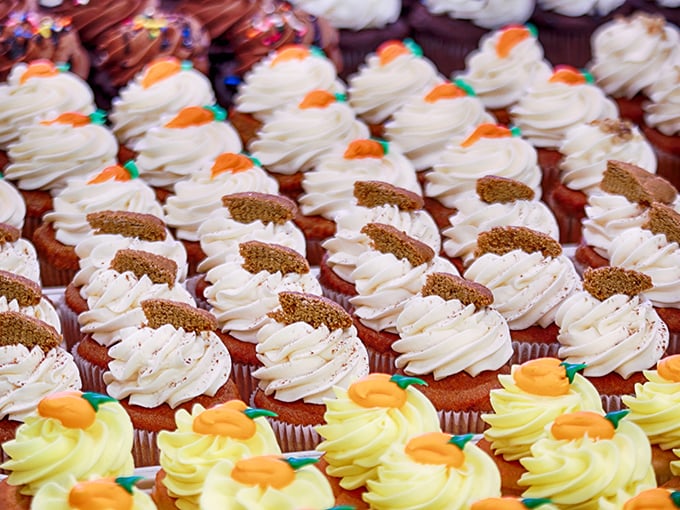 Cupcake perfection lined up like sweet soldiers ready for deployment to your taste buds. Those carrot decorations aren't fooling anyone—these aren't vegetables.