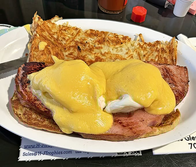 Eggs Benedict bringing that hollandaise perfection with hash browns that know exactly what they're doing on that plate.