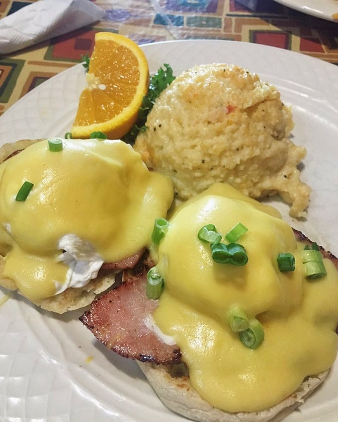 Eggs Benedict done right—poached eggs perched atop ham like royalty, draped in hollandaise that's basically sunshine in sauce form.