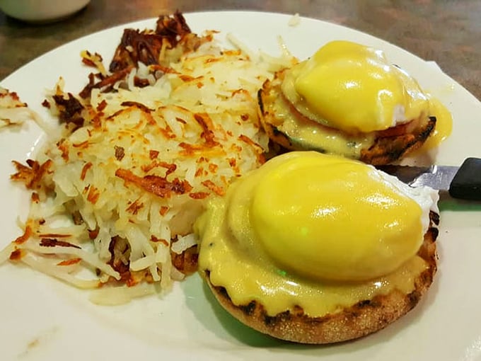 Eggs Benedict done right—golden hollandaise cascading over English muffins with hash browns crisped to perfection on the side.