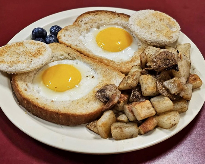 Eggs in a hole with home fries—breakfast engineering at its finest. Those sunny yolks are just waiting to break and create their own delicious sauce.