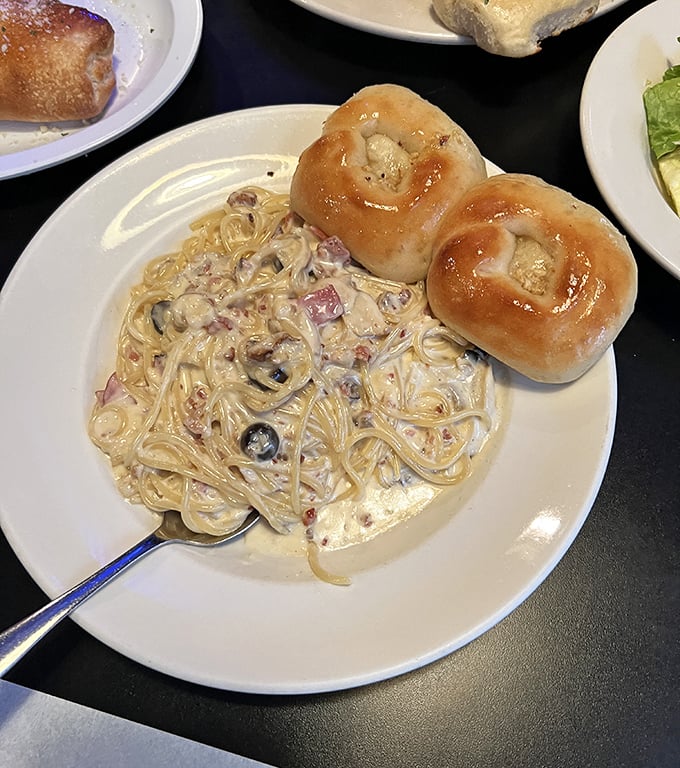 Fettuccine Alfredo with garlic knots – where cream sauce meets carbs in a romance more satisfying than any rom-com.