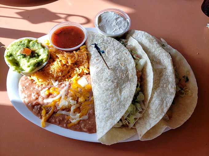 Fish tacos served with all the proper accessories – guacamole, salsa, rice, and beans – a coastal California quartet that never misses.