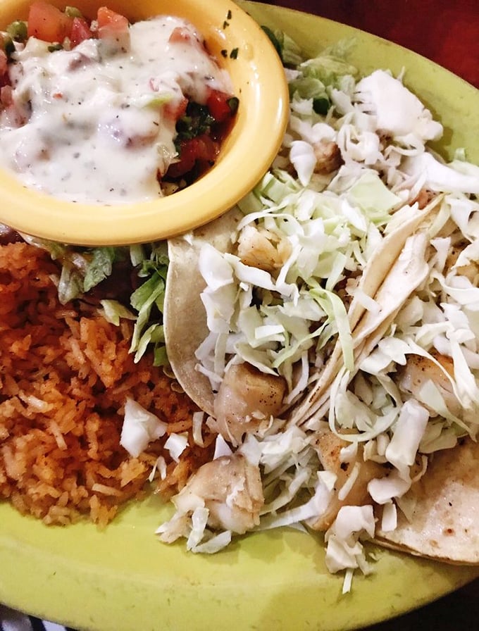 Fish tacos done right—crisp cabbage, tender fish, and a side of rice that didn't get the memo about being a mere afterthought.