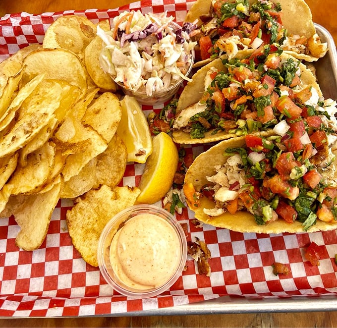 These fish tacos aren't just a meal—they're a fiesta on a metal tray. Fresh seafood meets vibrant pico de gallo in perfect harmony.