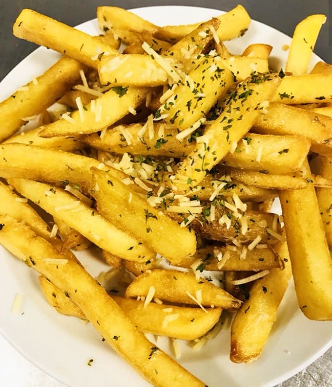 These aren't just fries—they're golden wands of potato perfection, dusted with herbs and parmesan that transform the humble spud into something magical.
