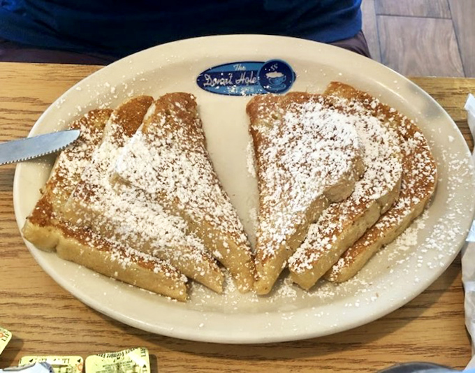 French toast dusted with powdered sugar like a sweet winter morning. The Donut Hole logo plate is their subtle way of saying "you're welcome."