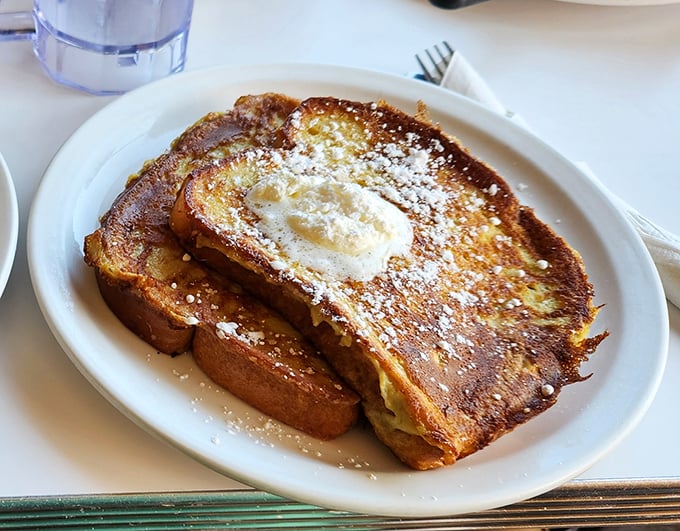 French toast that's achieved that mythical balance—crispy exterior, cloud-like interior. Dusted with powdered sugar like the first perfect snowfall of winter.