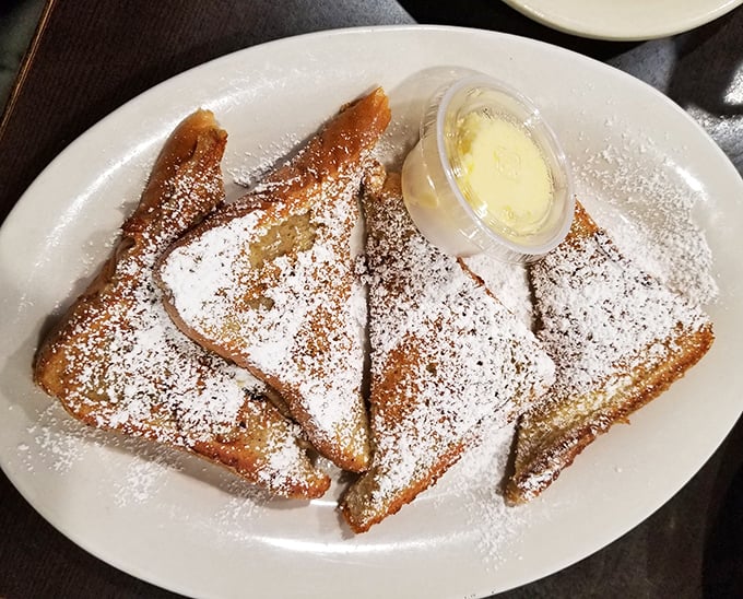 French toast that's dressed up in powdered sugar finery but keeps it casual with a side of butter—breakfast's perfect balance.