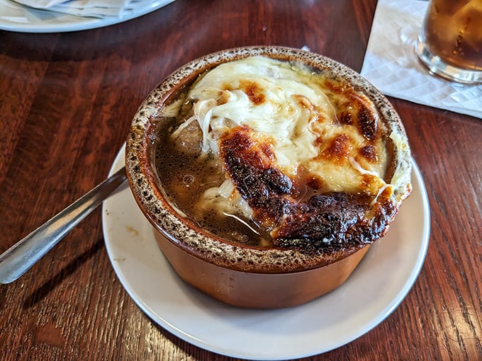 This French onion soup isn't just topped with cheese – it's wearing a magnificent crown of broiled provolone that's practically begging to be photographed.