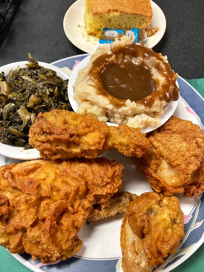 Fried chicken so perfectly golden it deserves its own trophy, alongside collard greens and mashed potatoes swimming in gravy. Southern comfort on a plate.