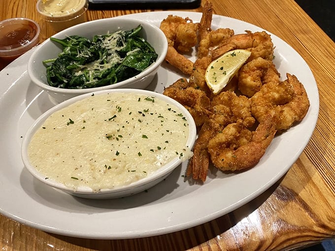 These aren't your average shrimp – they're crispy-coated celebrities of the sea, served with greens and grits that make vegetables exciting again.