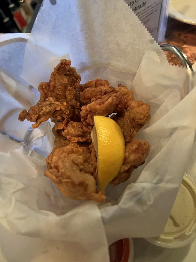 Fried oysters done right – crispy armor protecting briny treasures within, with that lemon wedge standing by for its supporting role.