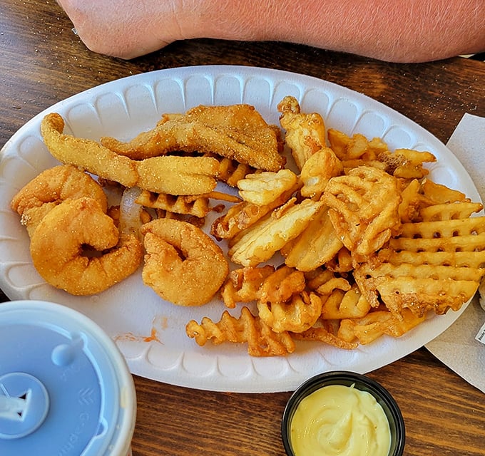 The seafood sampler plate—where indecision becomes a virtue. Crispy shrimp, golden perch, and waffle fries create the holy trinity of fried goodness.
