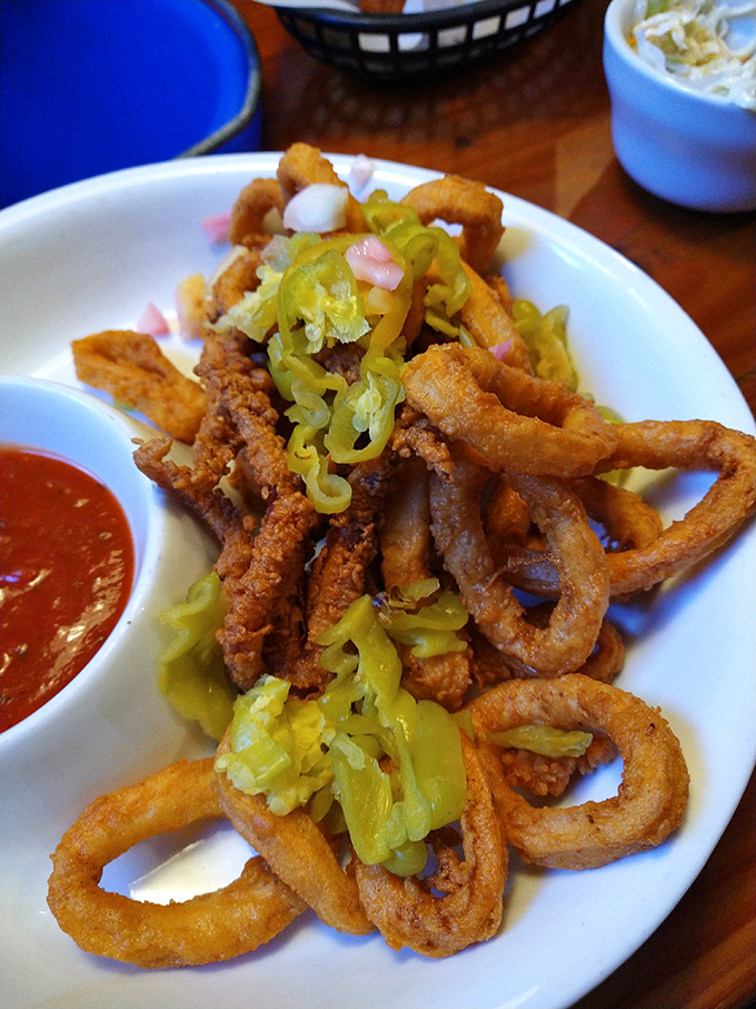 Crispy calamari rings topped with banana peppers—a textural symphony that proves fried food is indeed a love language.