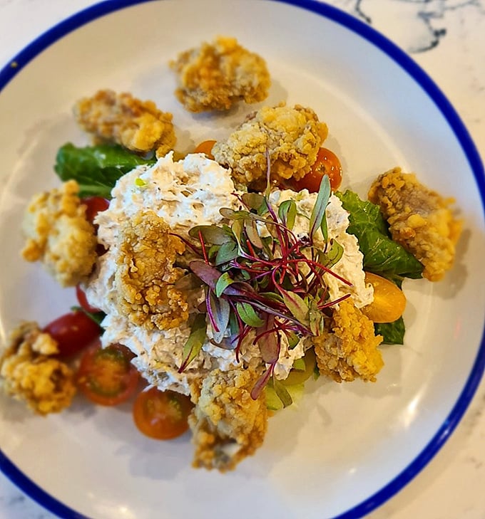 Fried oysters surrounded by microgreens and a creamy centerpiece. Ocean treasures transformed into crispy, briny bites of heaven.