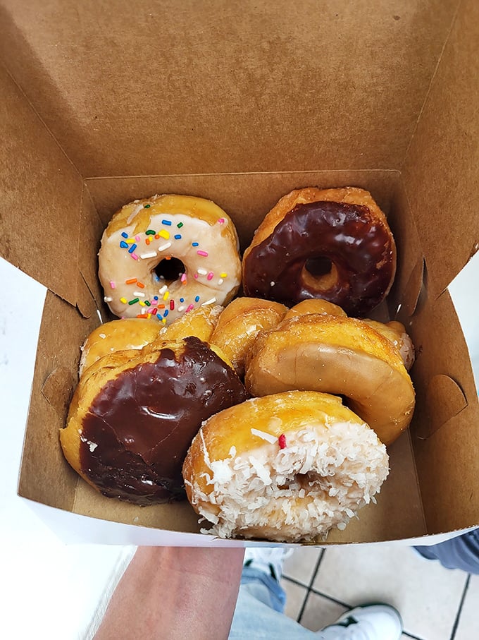 A box of joy containing sprinkles, chocolate, coconut, and glazed—the United Nations of donut diplomacy right in your hands.