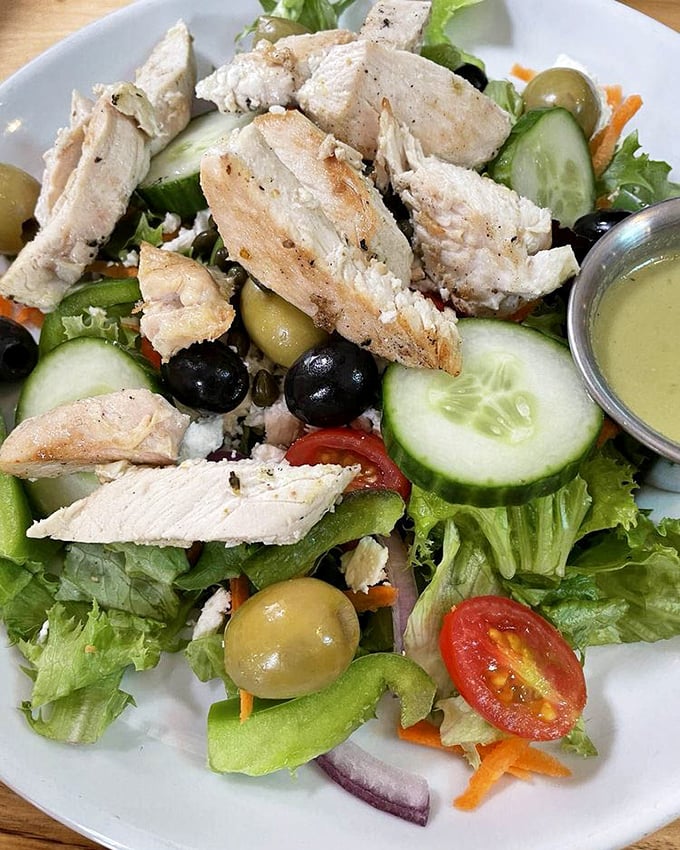 A Greek salad that respects both tradition and the chicken that gave its life for it—olives and feta playing supporting roles to perfectly seasoned protein.