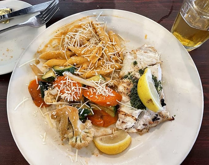 Perfectly grilled fish alongside pasta that's been thoroughly introduced to Parmesan. The lemon wedge isn't just garnish—it's essential punctuation.