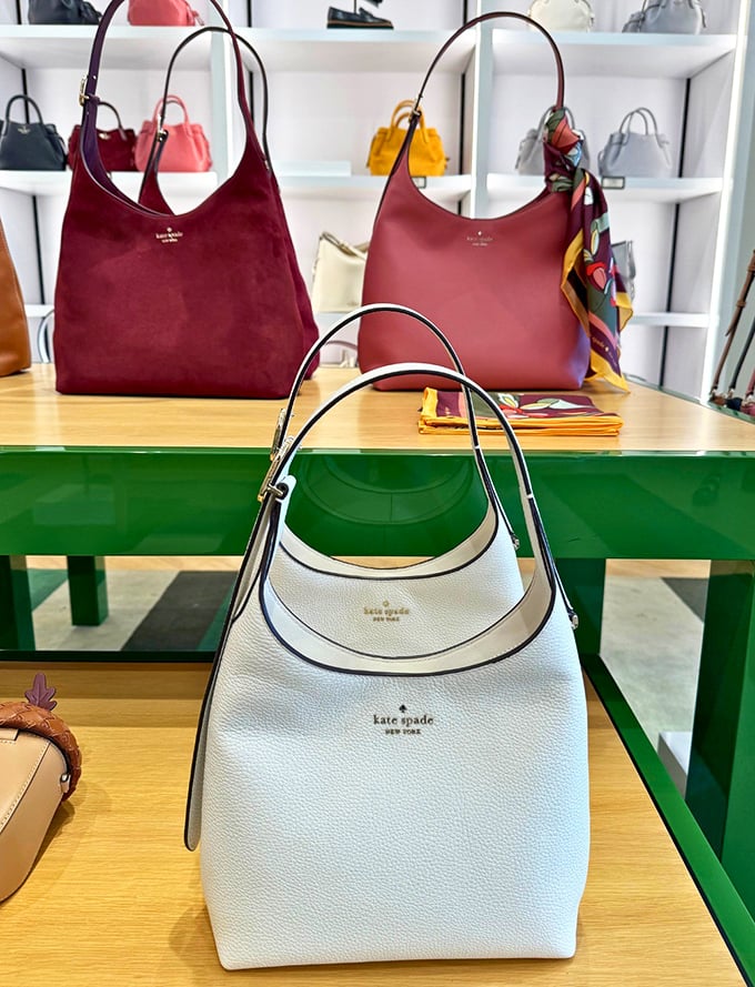 Kate Spade handbags arranged like fine art. That white leather tote isn't just a bag—it's your next faithful companion for California adventures.