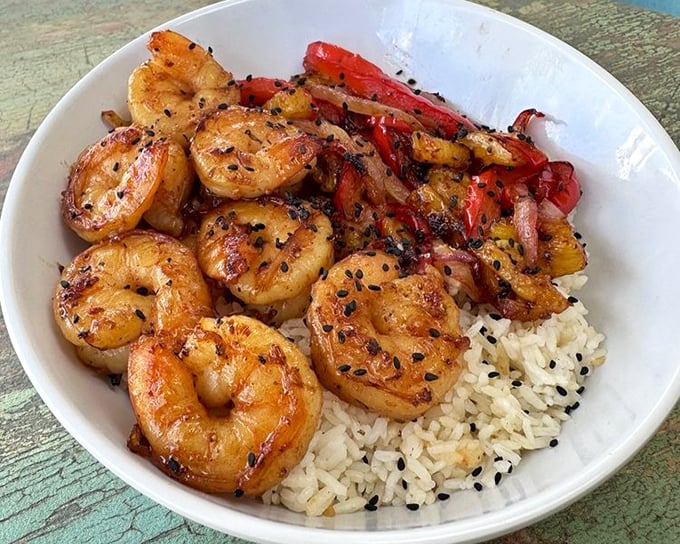 These perfectly seared shrimp perched atop rice aren't just dinner—they're a vacation for your taste buds, no passport required.