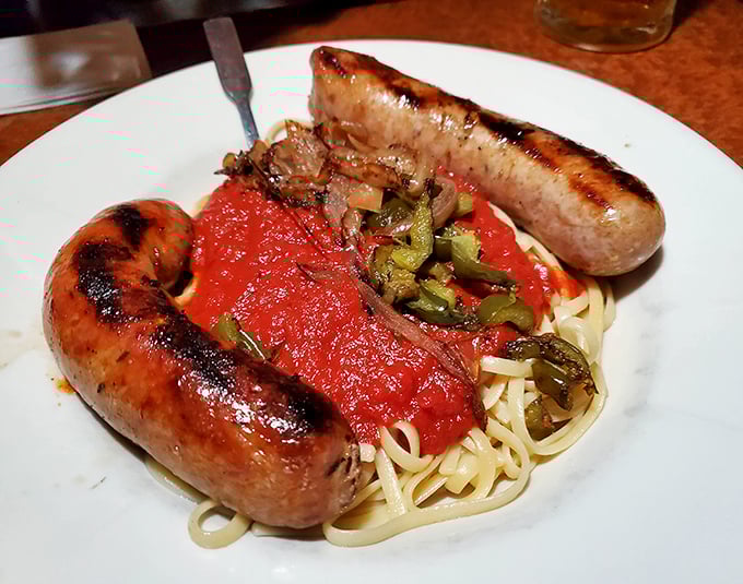 Italian sausages lounging on a bed of pasta like they're on vacation in Sicily – a beautiful sight that makes your fork hand twitch with anticipation.