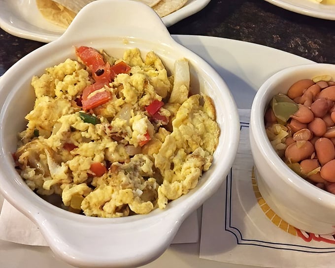 Scrambled eggs studded with fresh vegetables alongside beans – proof that breakfast knows no borders at this neighborhood gem.