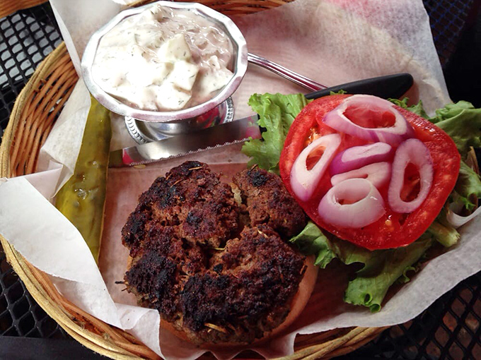 The blackened lamb burger arrives with all the fanfare it deserves—juicy, perfectly seasoned, and ready for its close-up with those vibrant red onions.