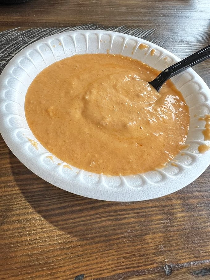 A velvety orange sea of lobster bisque awaits your spoon—rich, creamy, and carrying whispers of the ocean in every steaming spoonful.
