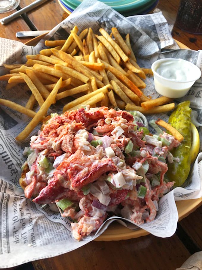 The lobster roll that launched a thousand road trips—chunks of sweet meat barely contained by their bread vessel, no passport required.