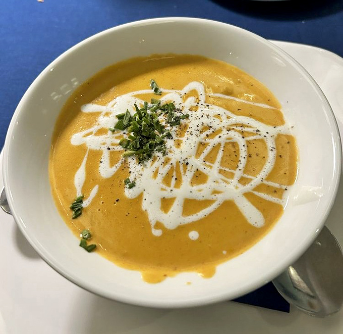 This lobster bisque isn't just orange – it's a sunset-colored pool of velvety decadence with artistic cream swirls worthy of a gallery.